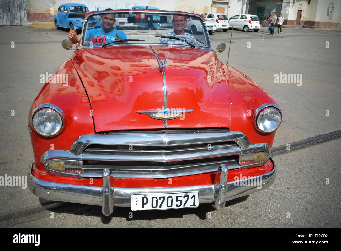 Gleaming red, vintage, soft top taxi, with driver and passenger ready ...
