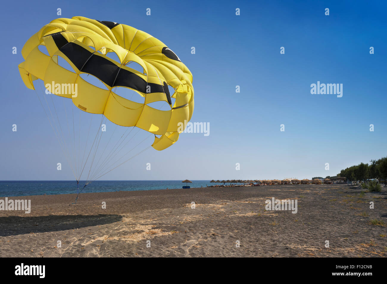 A yellow parachute on Perissa beach in Santorini, Greece Stock Photo ...