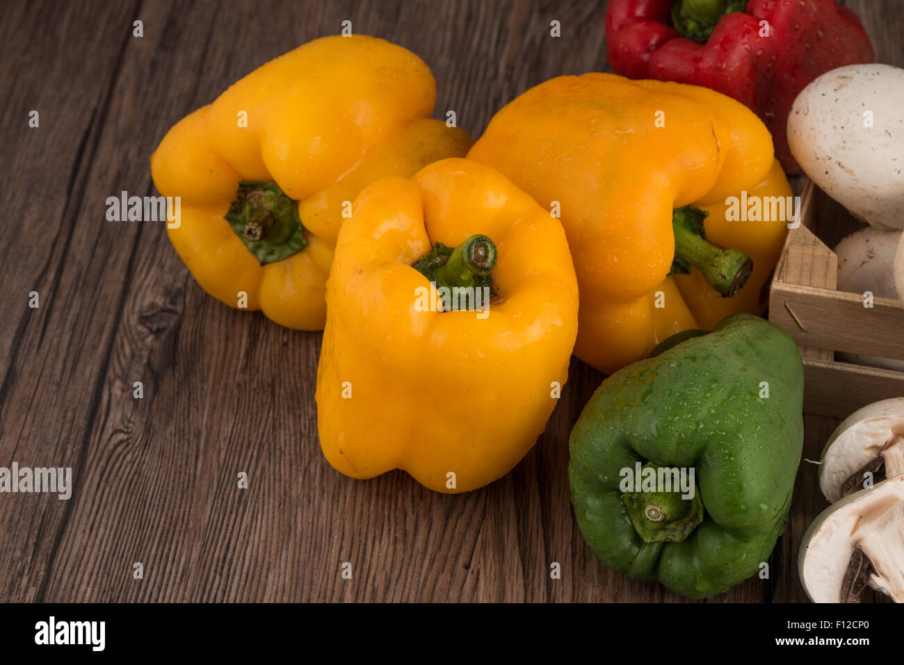 Colored bell peppers on old wooden table Stock Photo - Alamy