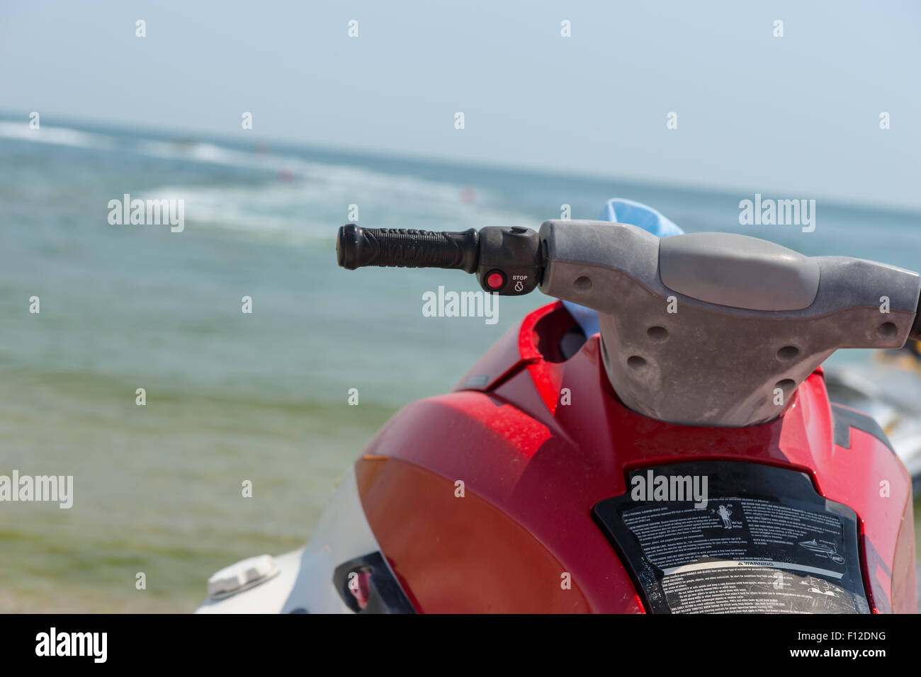 Red jet ski in shallow water off the beach ready to head out to sea ...