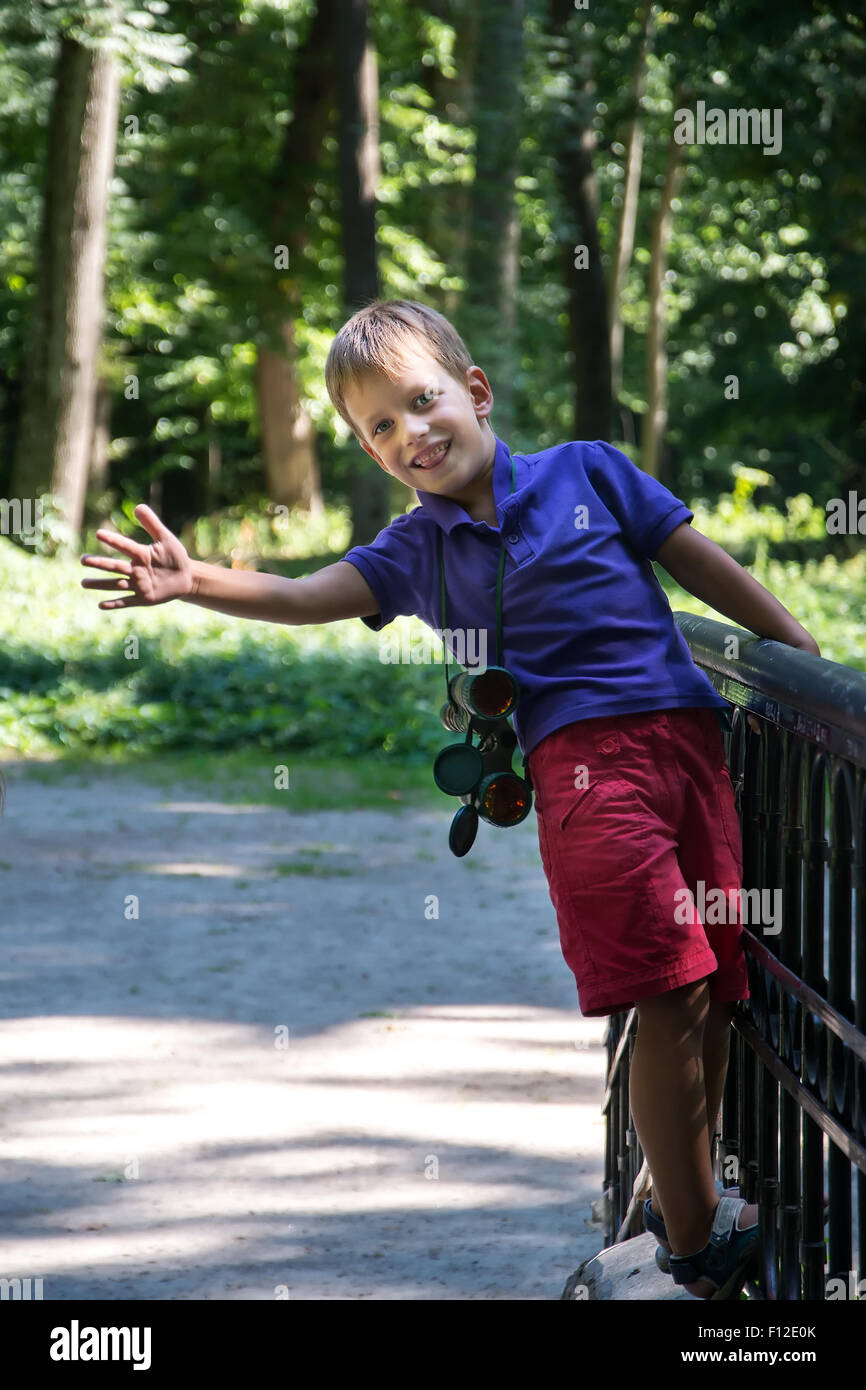 Boy on bridge shaking his hand with binoculars Stock Photo - Alamy