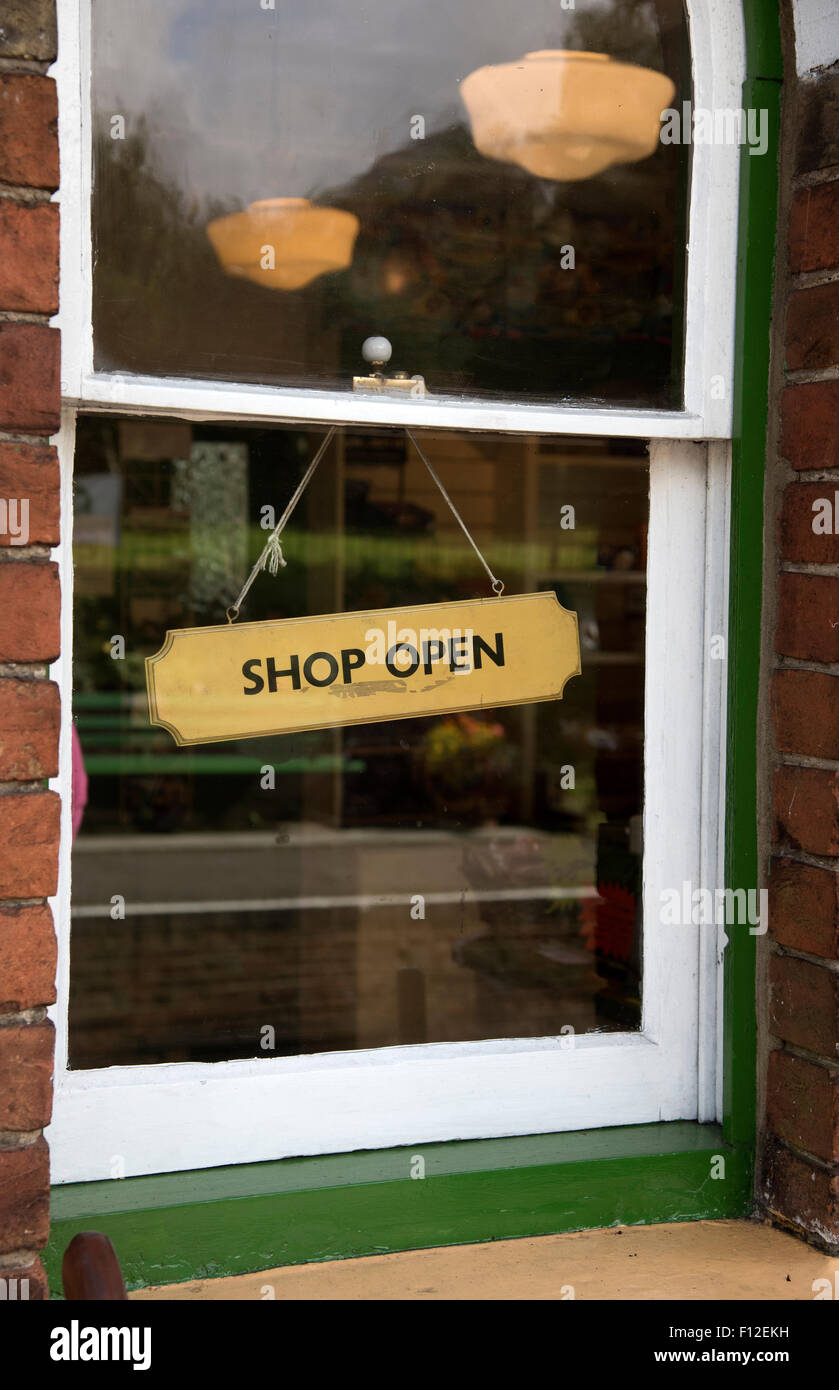 Shop open a hanging sign in shop window Stock Photo - Alamy