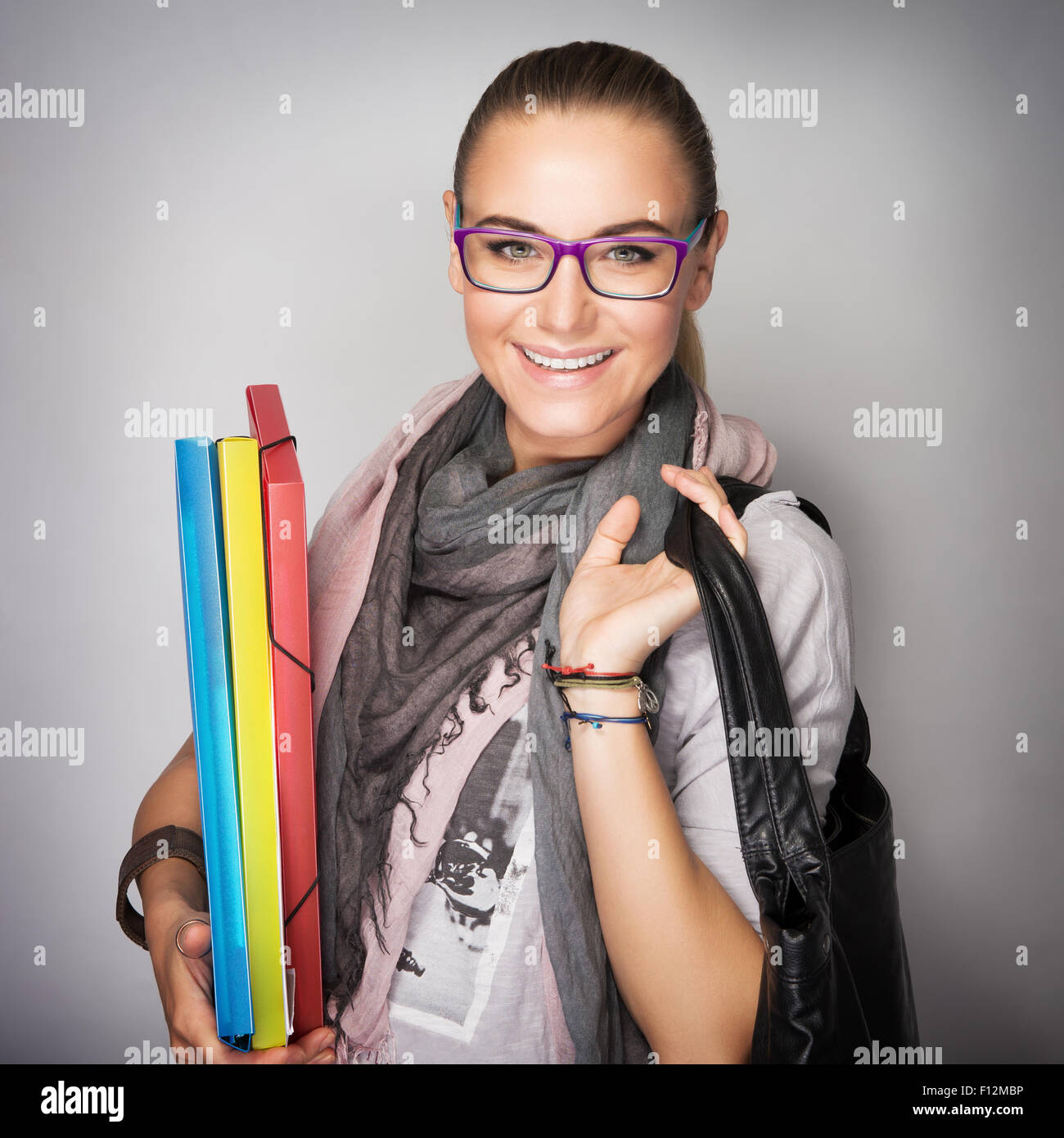 Portrait of beautiful smart student girl wearing glasses, standing with ...
