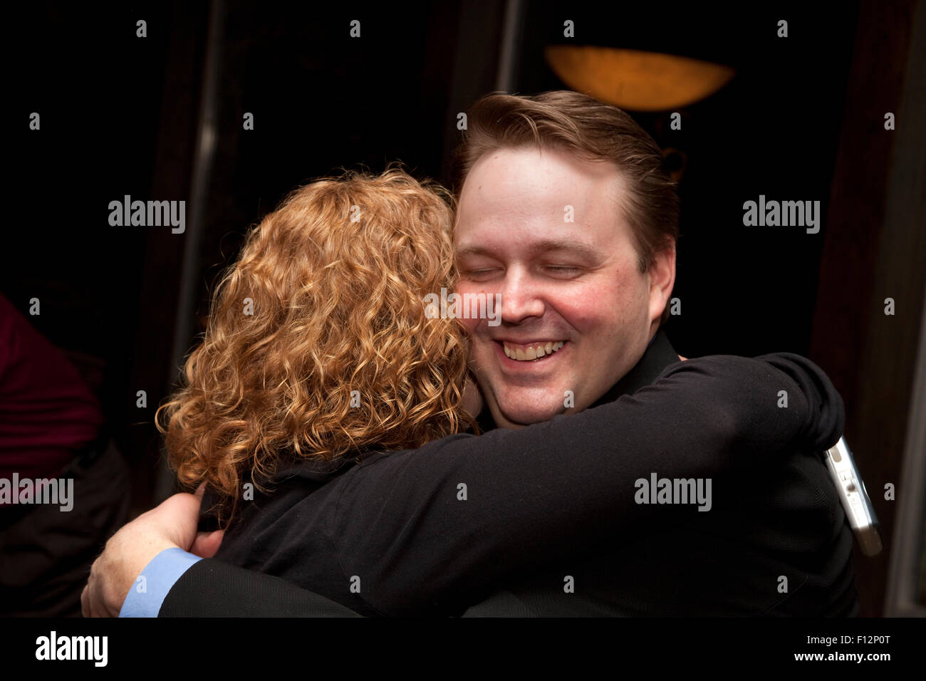 Cousins age 46 and 41 embracing at mothers 70th birthday party. St Paul ...