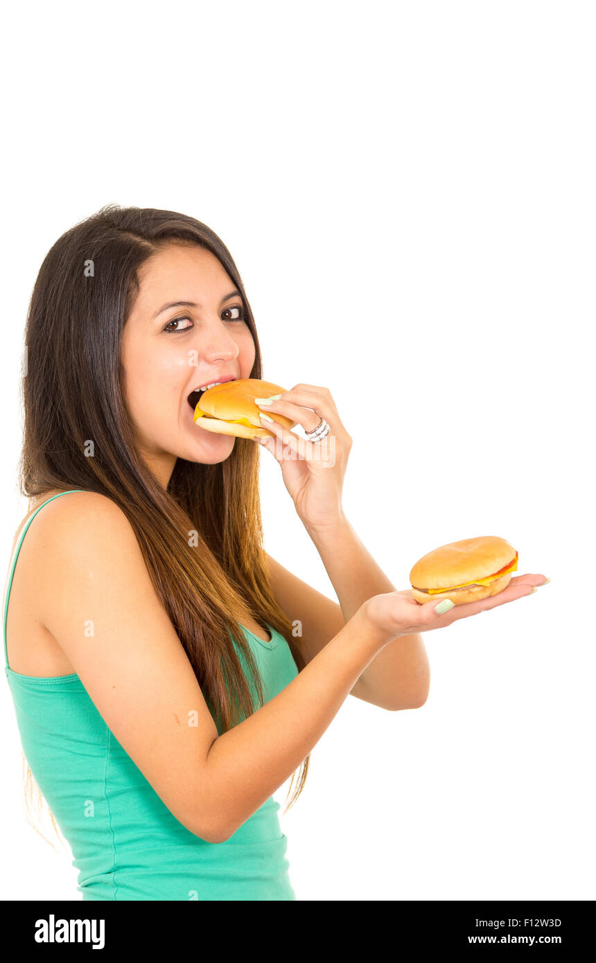 Hispanic brunette model wearing turquoise top eating hamburger with one ...