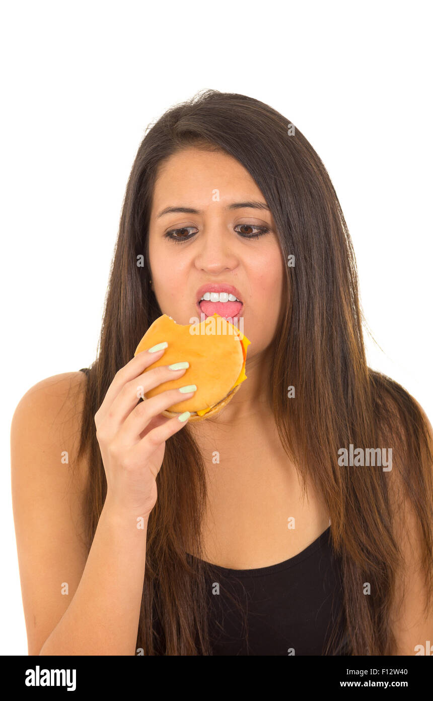 Hispanic brunette model wearing black top eating hamburger looking at ...