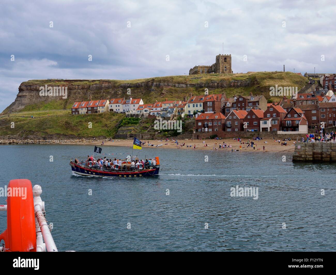 Church on a hill with a tourist boat in the foreground and a pier and ...