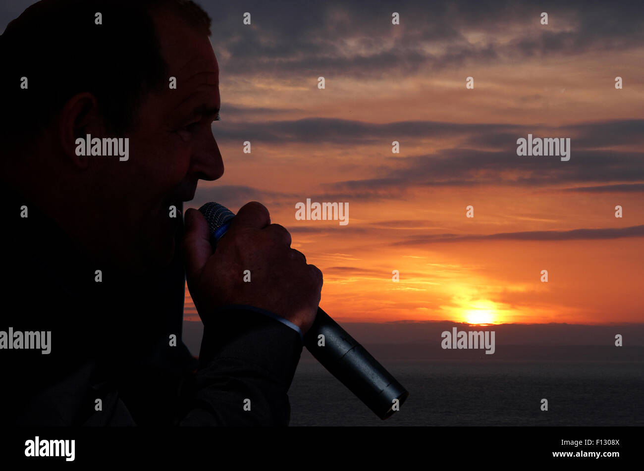 Man singing with sunset background Stock Photo - Alamy