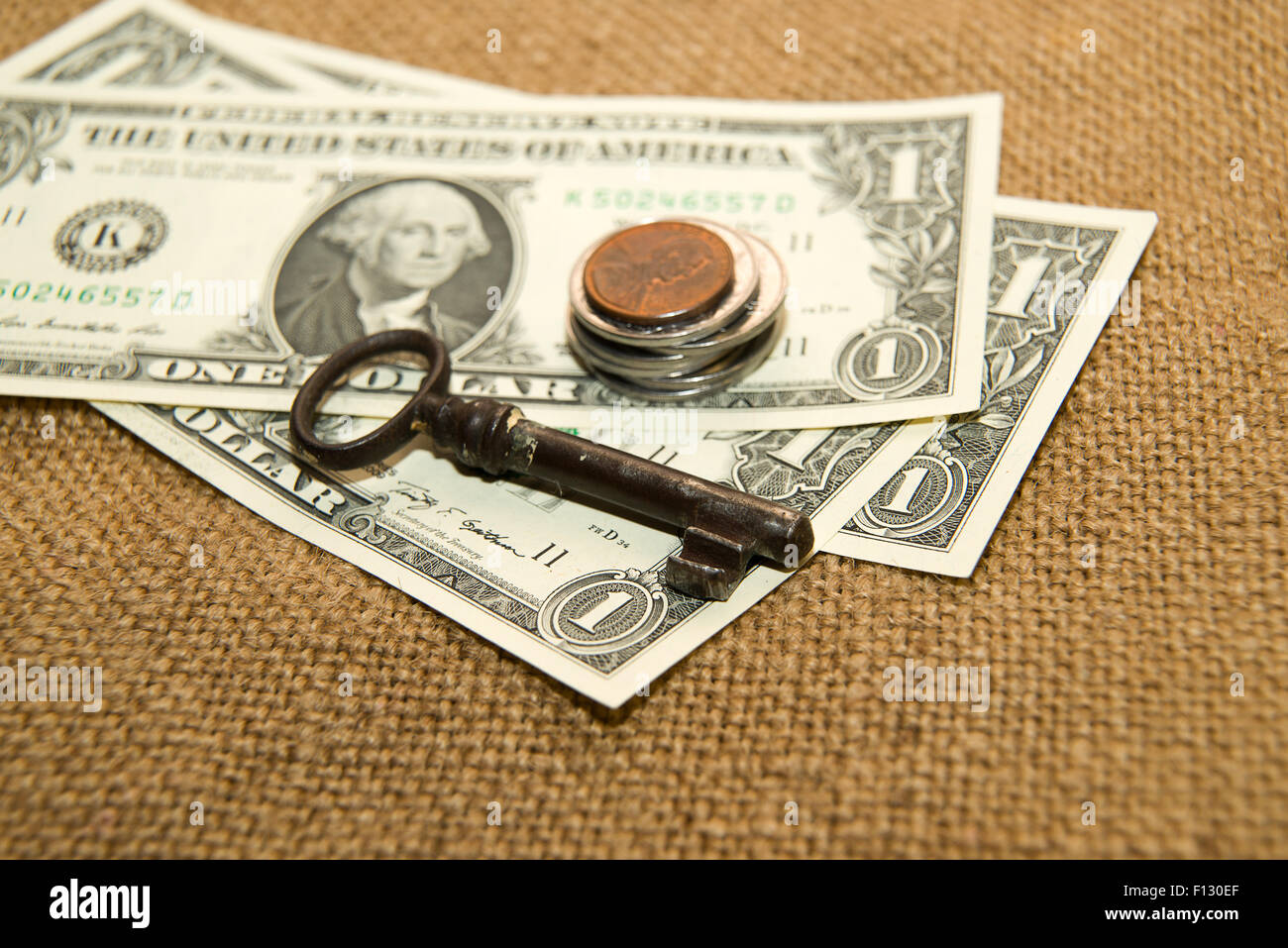 Dollars banknotes, coins and key on an old cloth Stock Photo - Alamy
