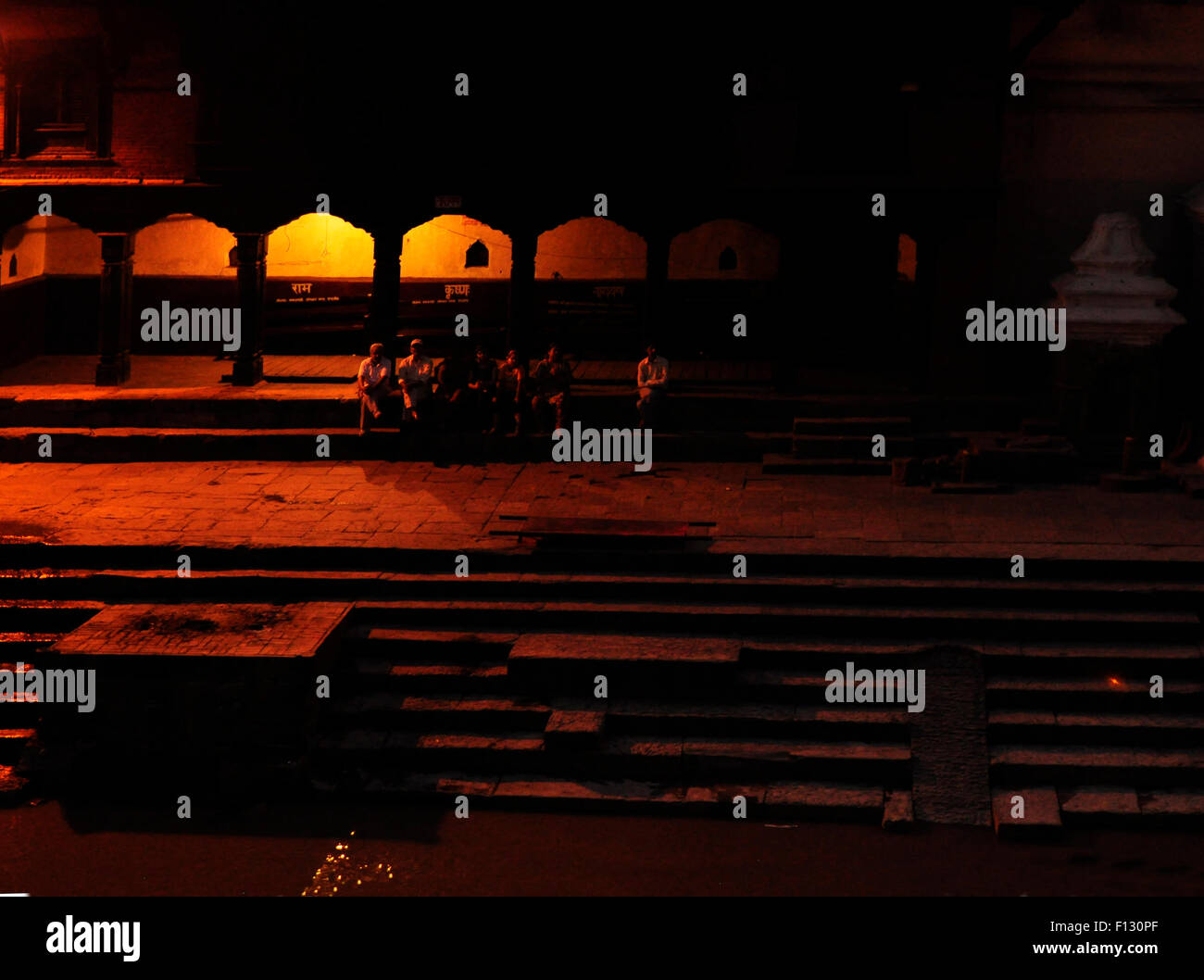Family grieving after the cremation ceremony at the burning ghat pyre ...