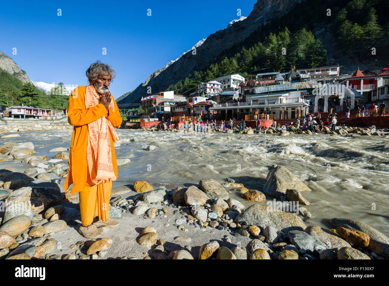 A devotee is praying at the waterfront of the young river Ganges, an ...