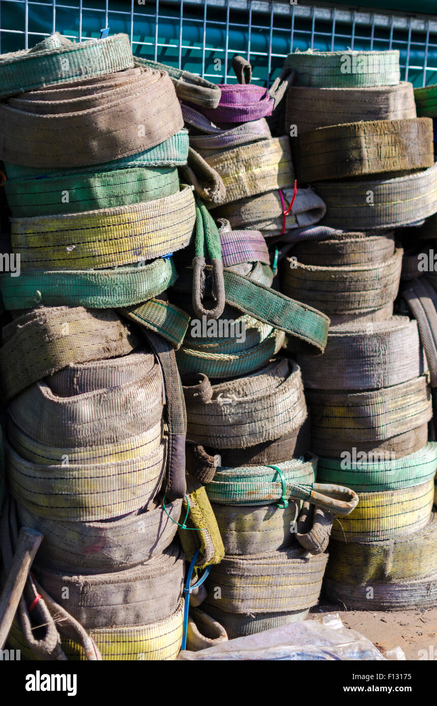 Cooils of old webbing load restraints stacked in a pile Stock Photo - Alamy
