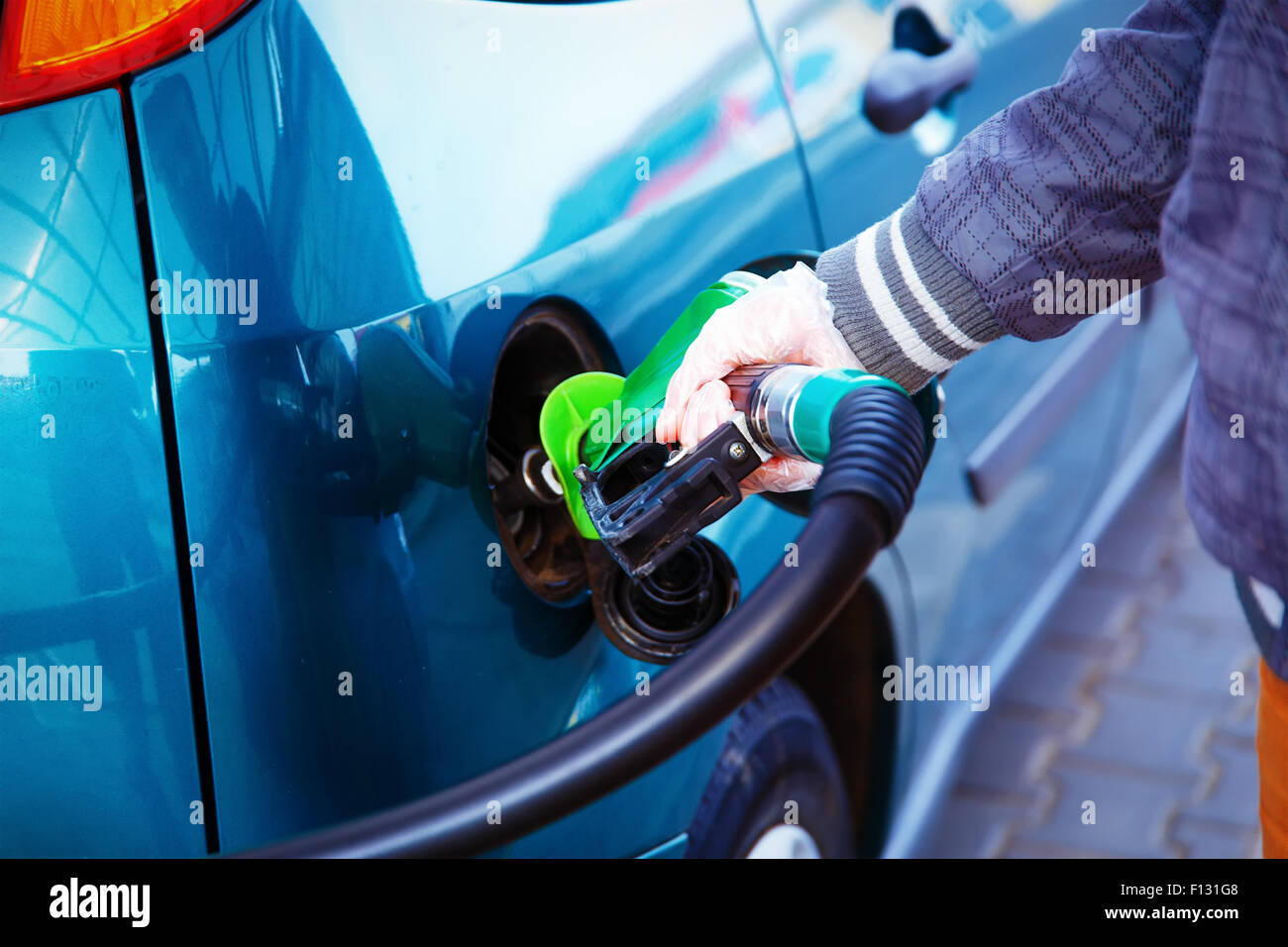 man pumping gasoline fuel in car at gas station. transportation concept ...