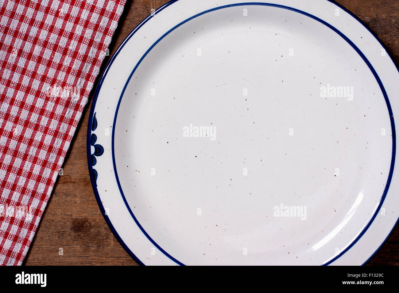 Plates and table cloth on wooden table with copy space Stock Photo - Alamy