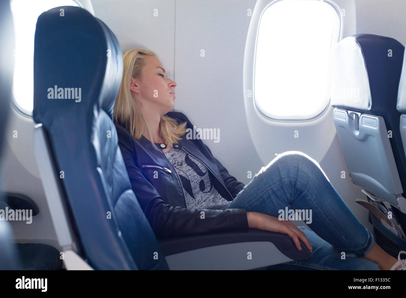 Lady traveling napping on a plain Stock Photo - Alamy