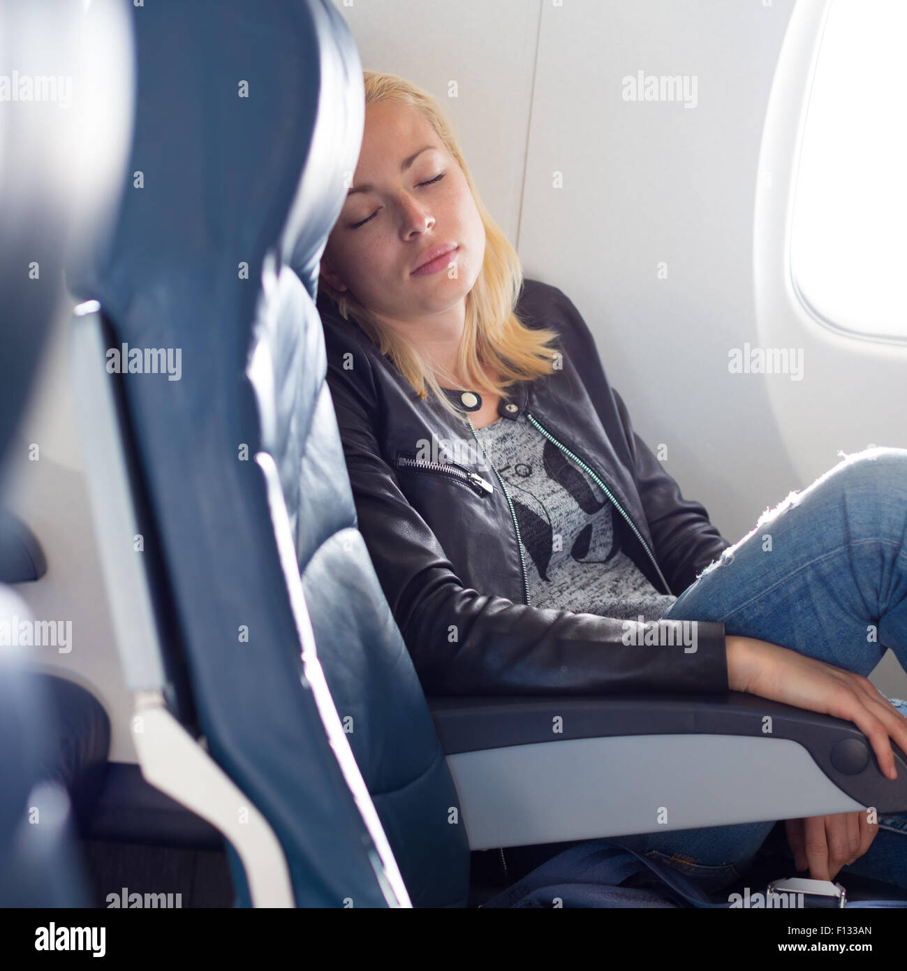 Lady traveling napping on a plain Stock Photo - Alamy
