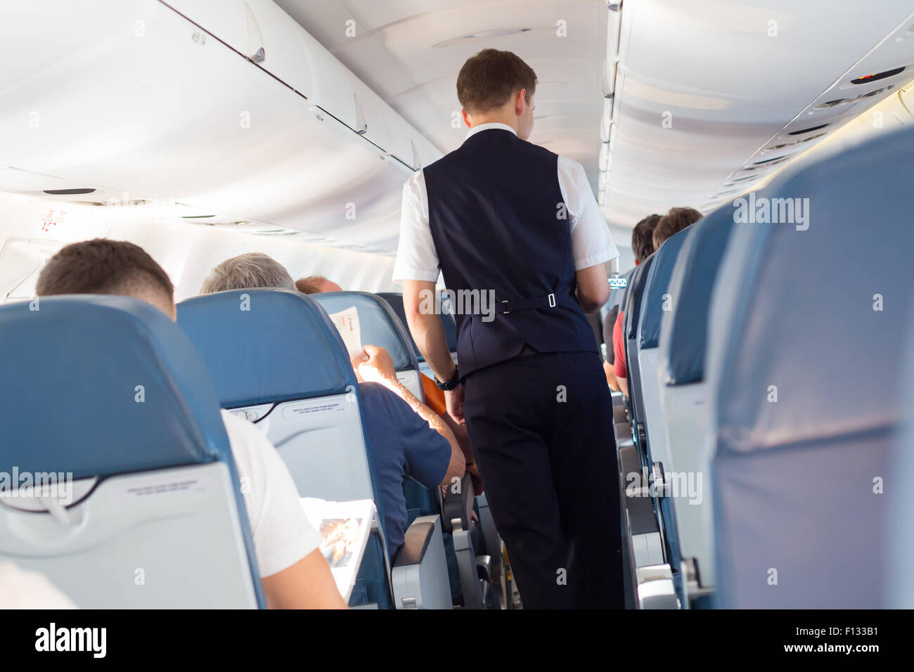 Steward on the airplane Stock Photo - Alamy