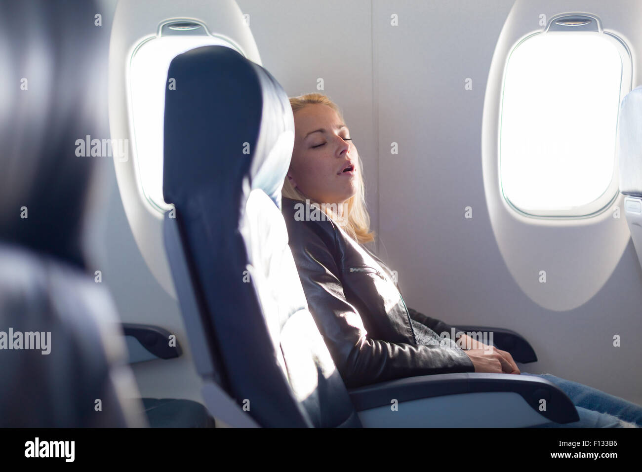 Lady traveling napping on a plain Stock Photo - Alamy