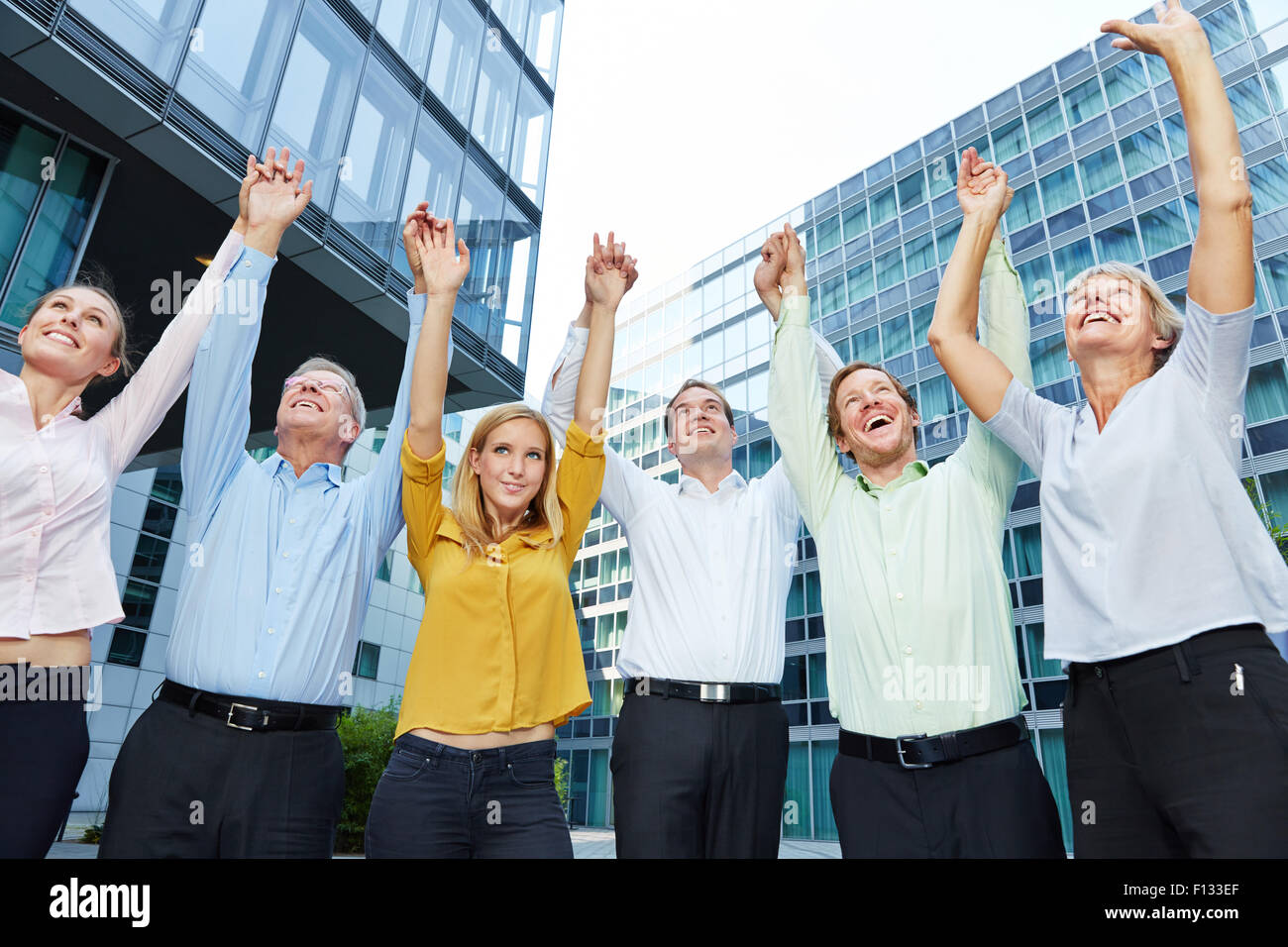 Happy business people lifting arms up together for motivation Stock ...