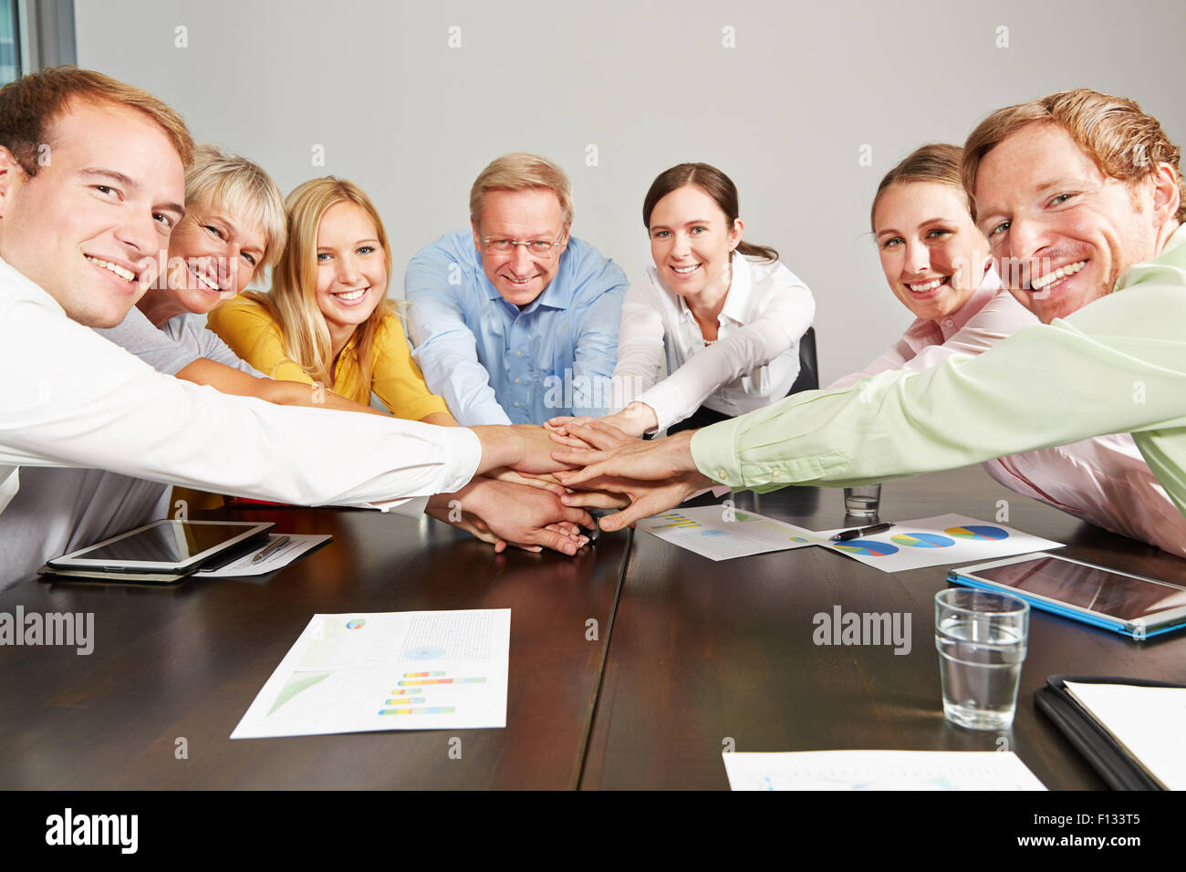 Many business people stacking their hands for motivation in the office ...