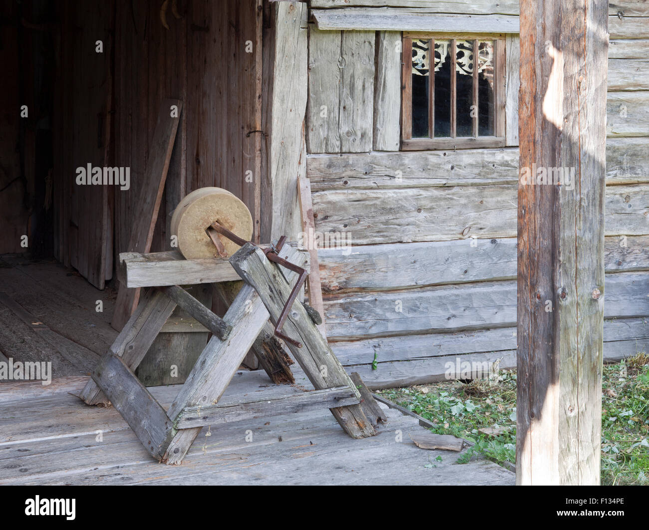 A grindstone in a wooden construction at a workshop. Elderly timber ...