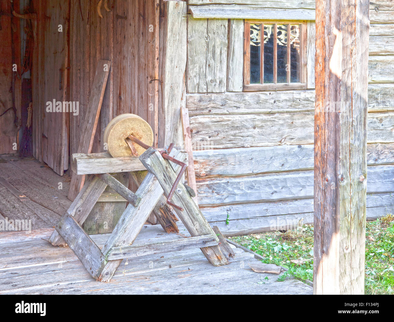 A grindstone in a wooden construction at a workshop. Elderly timber ...