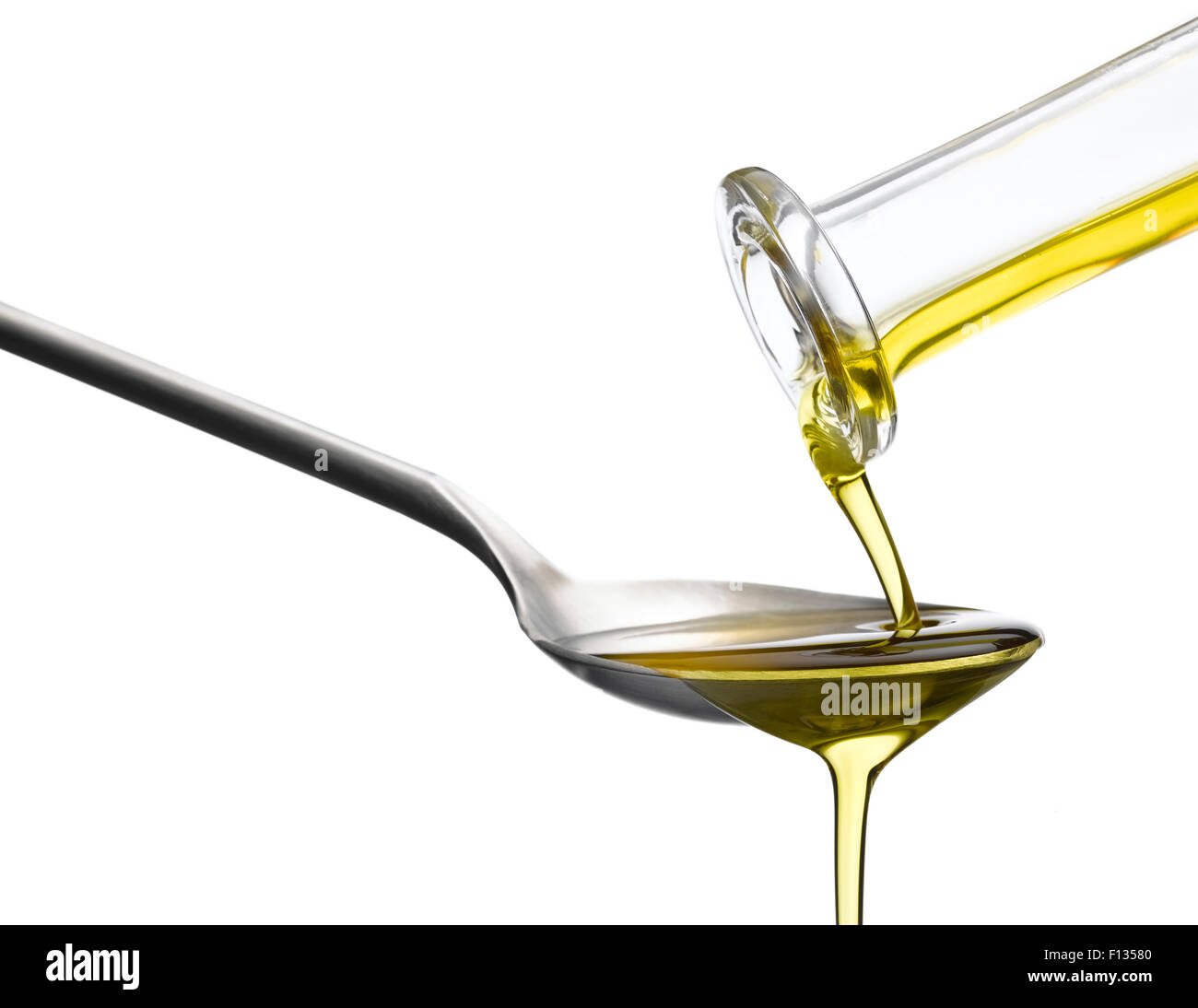 Oil pouring onto a spoon with a white background Stock Photo - Alamy