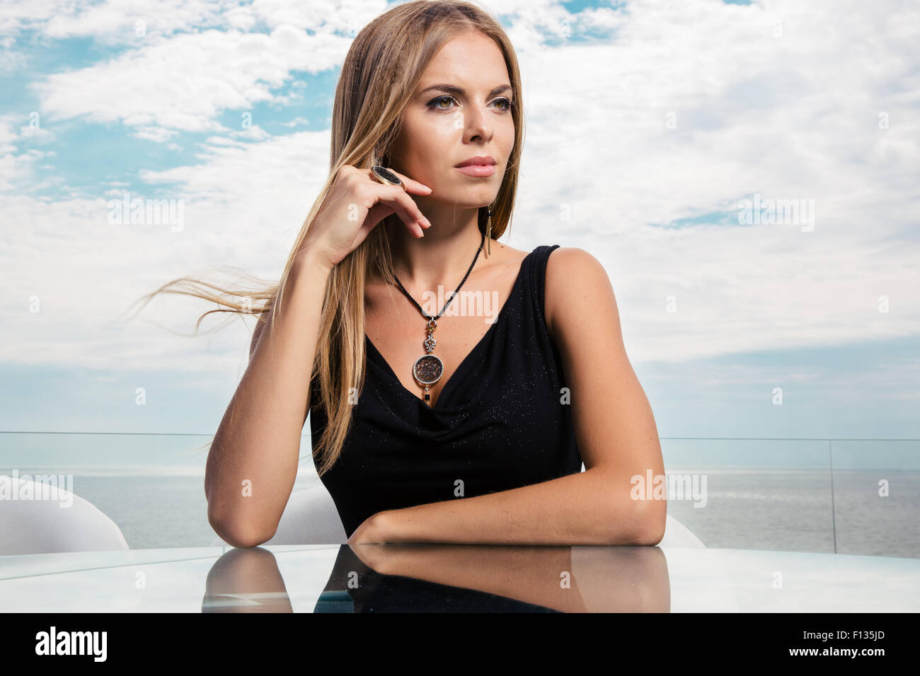 Portrait of a beautiful woman sitting at the table in cafe outdoors ...