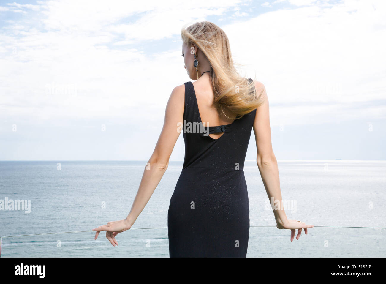 Back view portrait of a stylish woman standing in fashion dress with ...