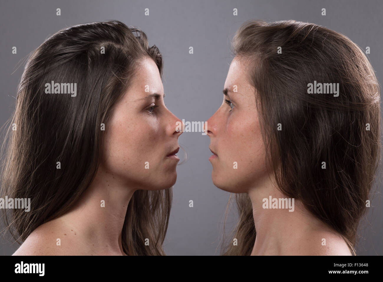 Two Serious Twin Sisters Looking at Each Other Stock Photo - Alamy