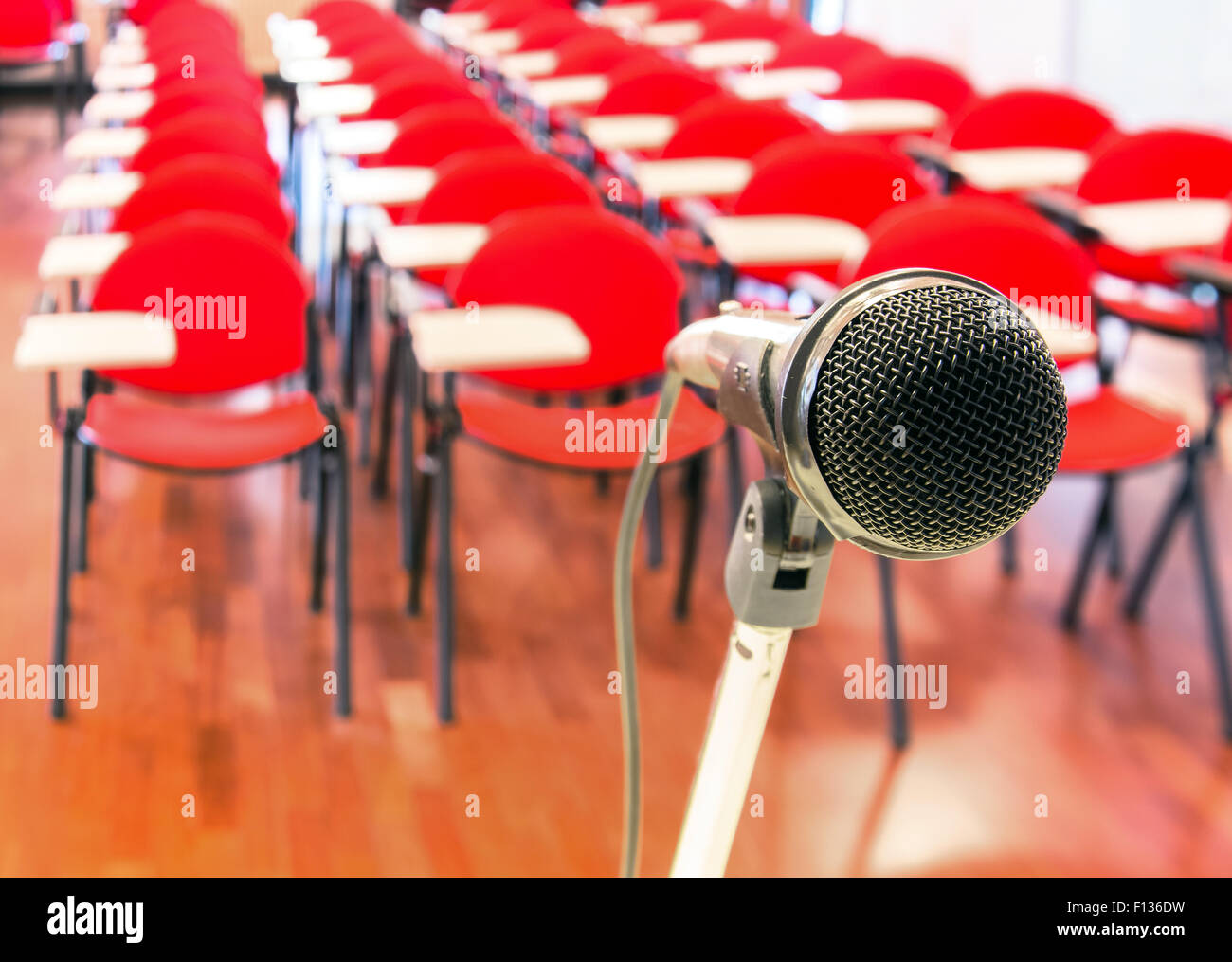 Close up of microphone in front of empty chairs in conference room ...