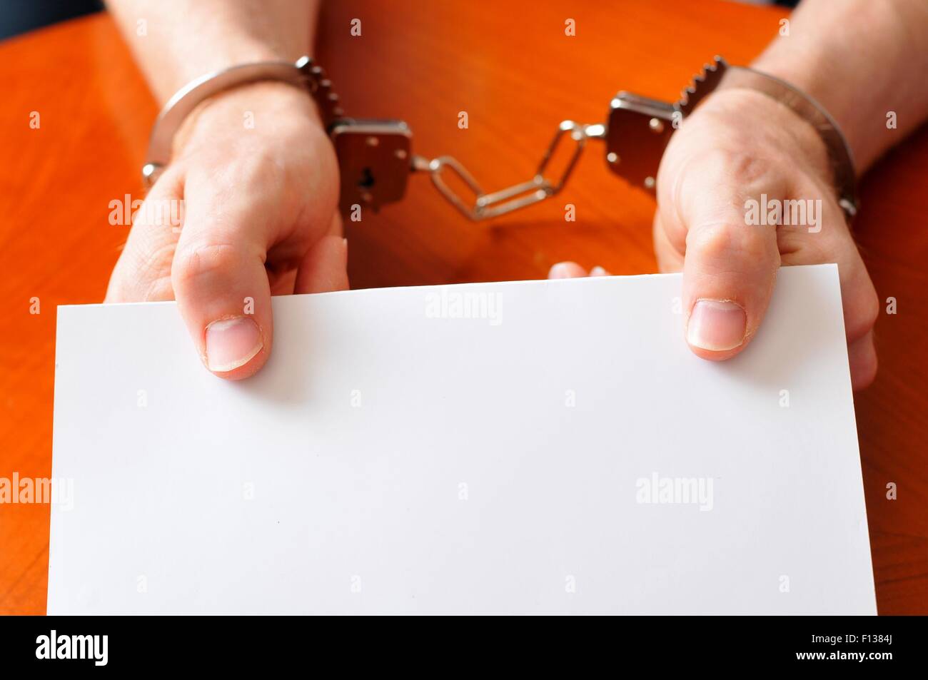 Convict with handcuffs shows blank card Stock Photo - Alamy