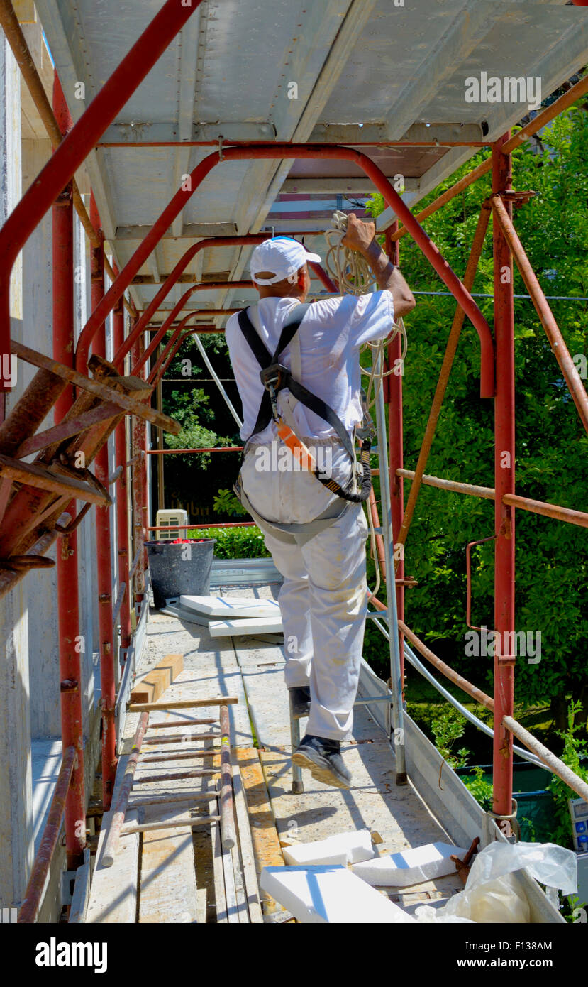 Safety at work. Worker assembles a scaffold Stock Photo - Alamy
