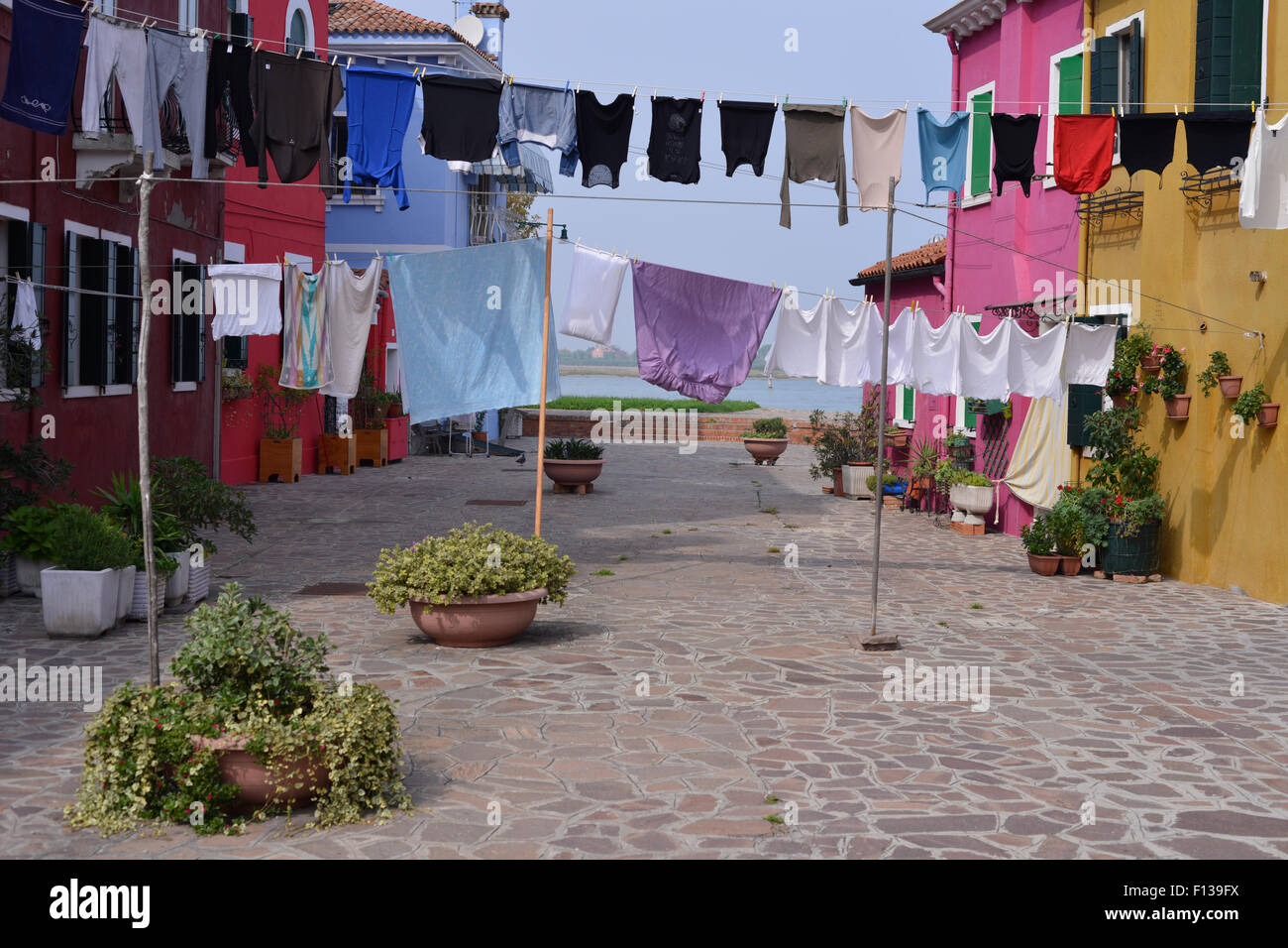 Clothes drying on lines between colourful houses in Burano, Venice ...