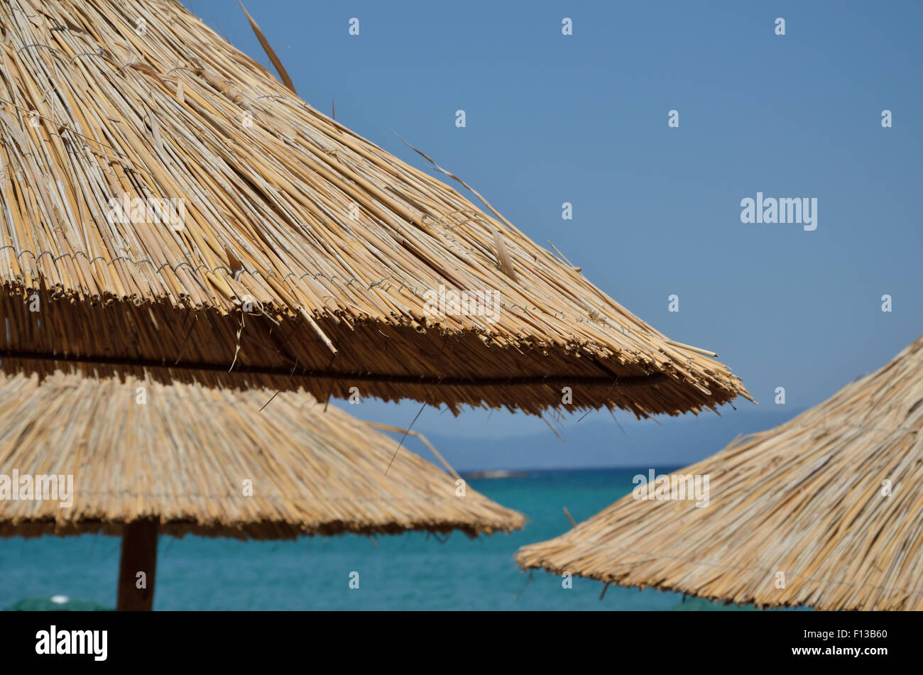 Beach straw parasols with blue sky and turquoise sea Stock Photo - Alamy