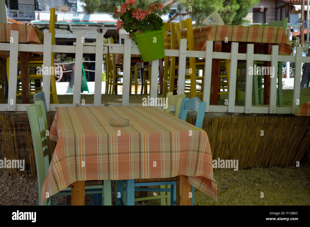 Table with chairs in colorful Greek restaurant Stock Photo - Alamy