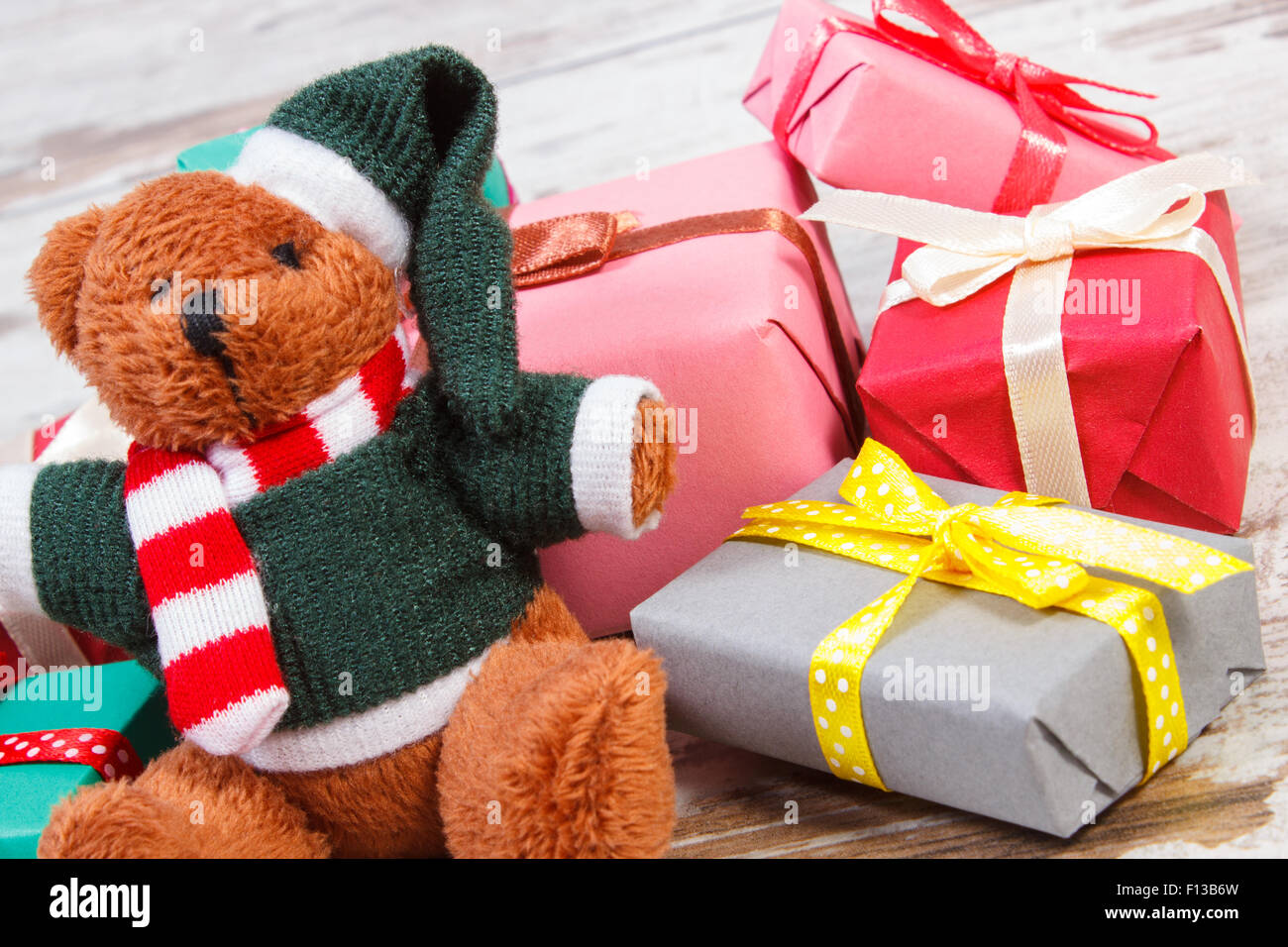 Fluffy teddy bear and heap of wrapped colorful gifts for Christmas ...