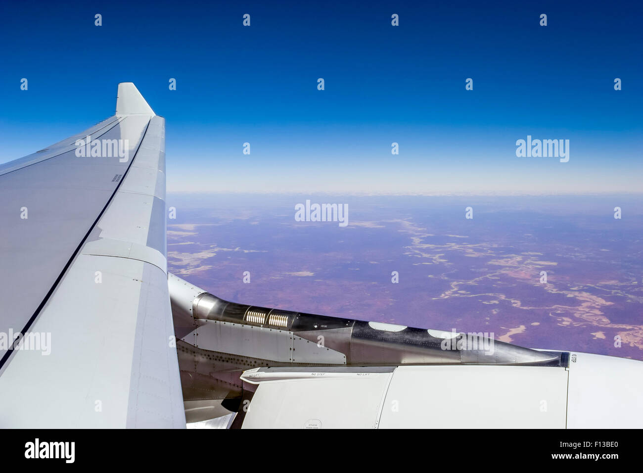 Window seat view whilst flying in a commercial aircraft over the red ...