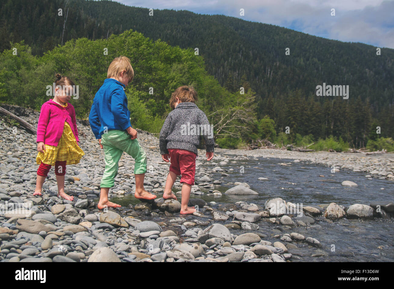 Three children playing by a stream Stock Photo - Alamy