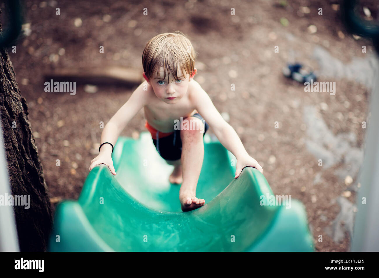 Boy climbing up a slide Stock Photo - Alamy