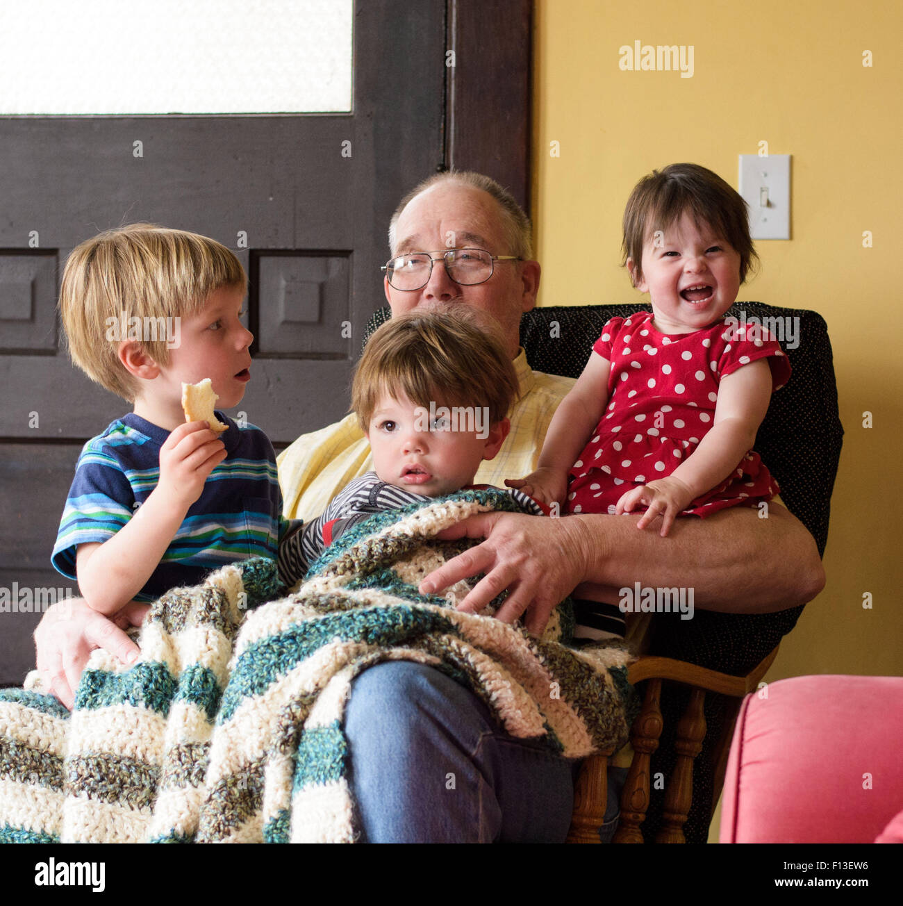 Three children sitting on their grandfather's lap Stock Photo - Alamy