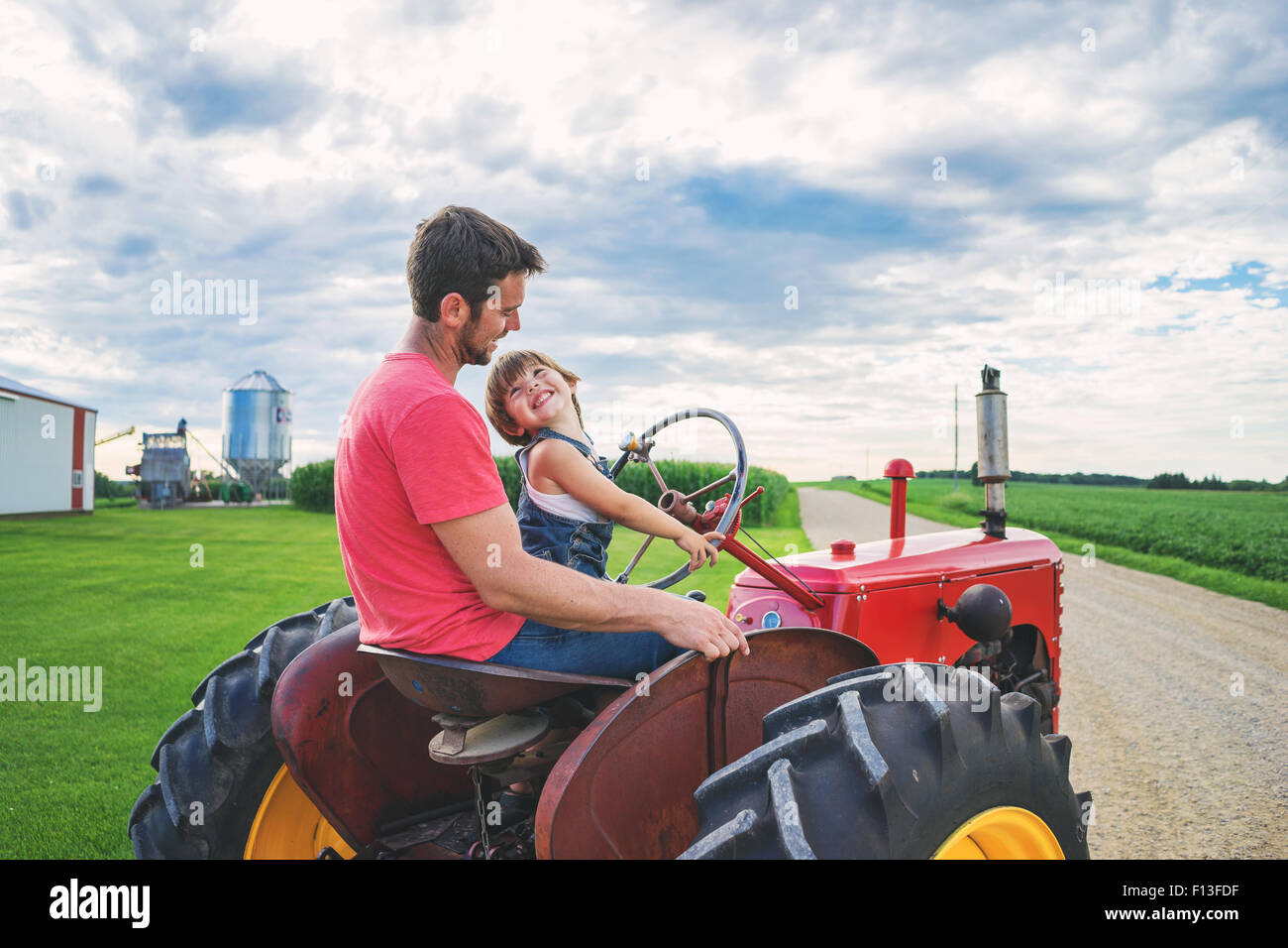 Father driving a tractor with his son, USA Stock Photo - Alamy