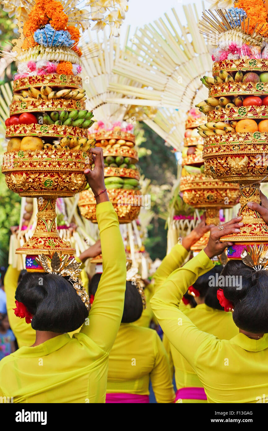 Procession of beautiful Balinese women in traditional costumes carry ...