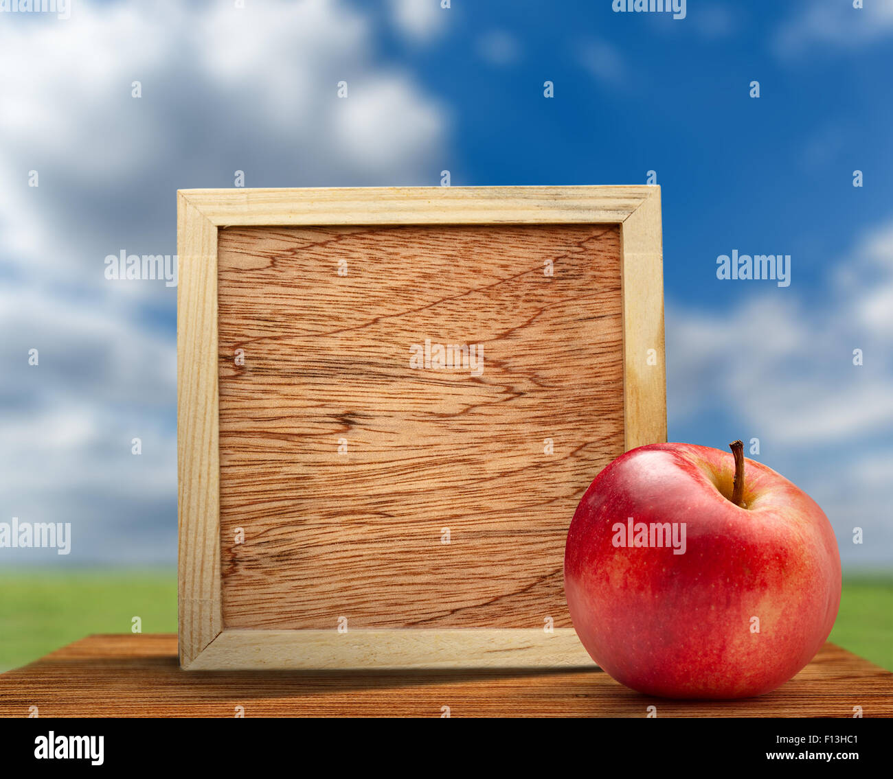 Red apple with wooden frame on nature background Stock Photo - Alamy