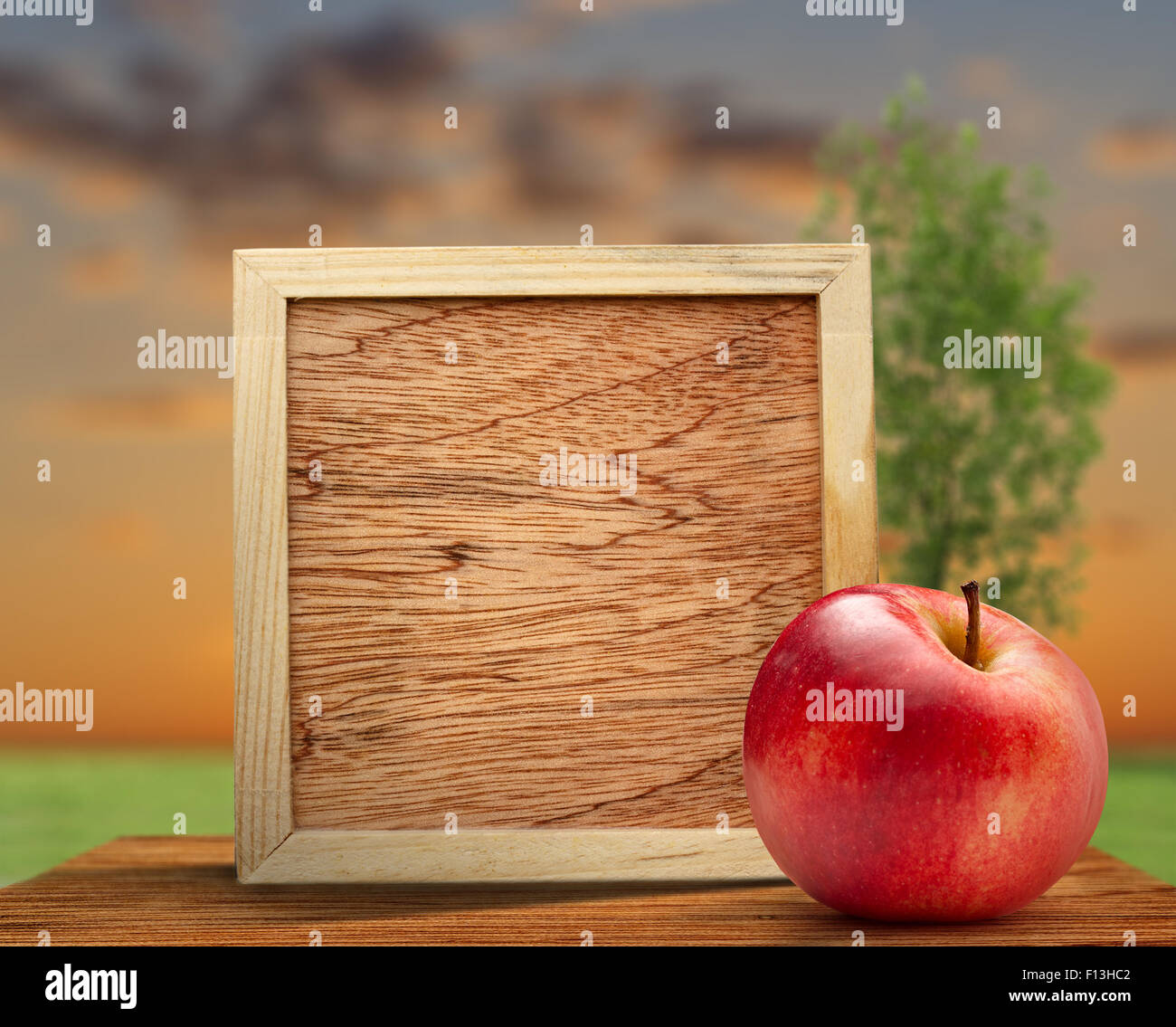 Red apple with wooden frame on nature background Stock Photo - Alamy