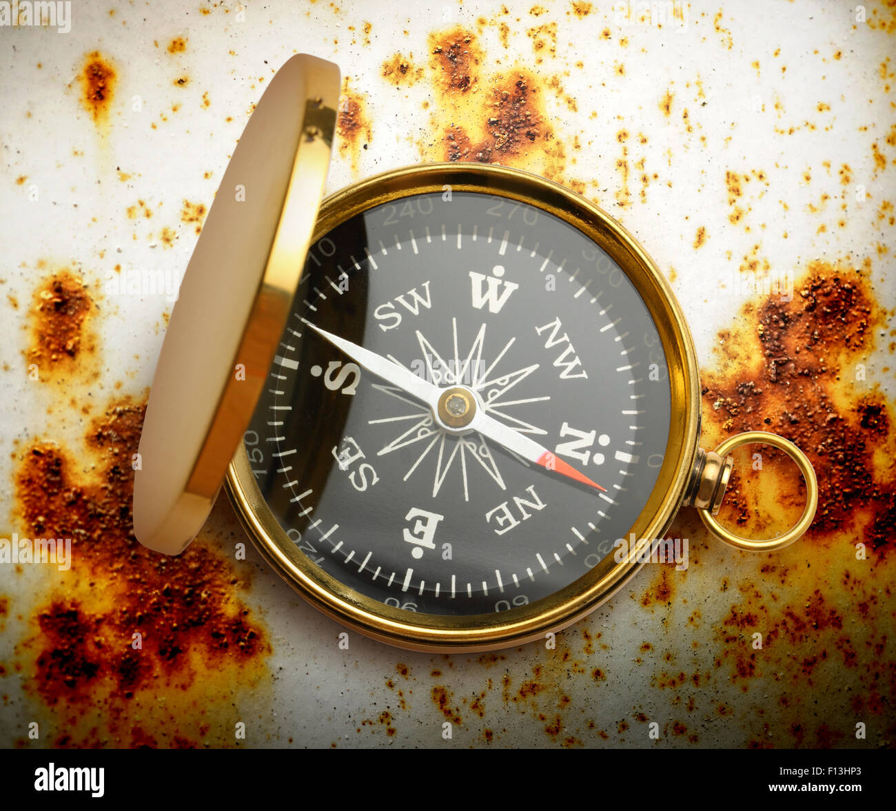Golden vintage compass opened on rusty background Stock Photo - Alamy