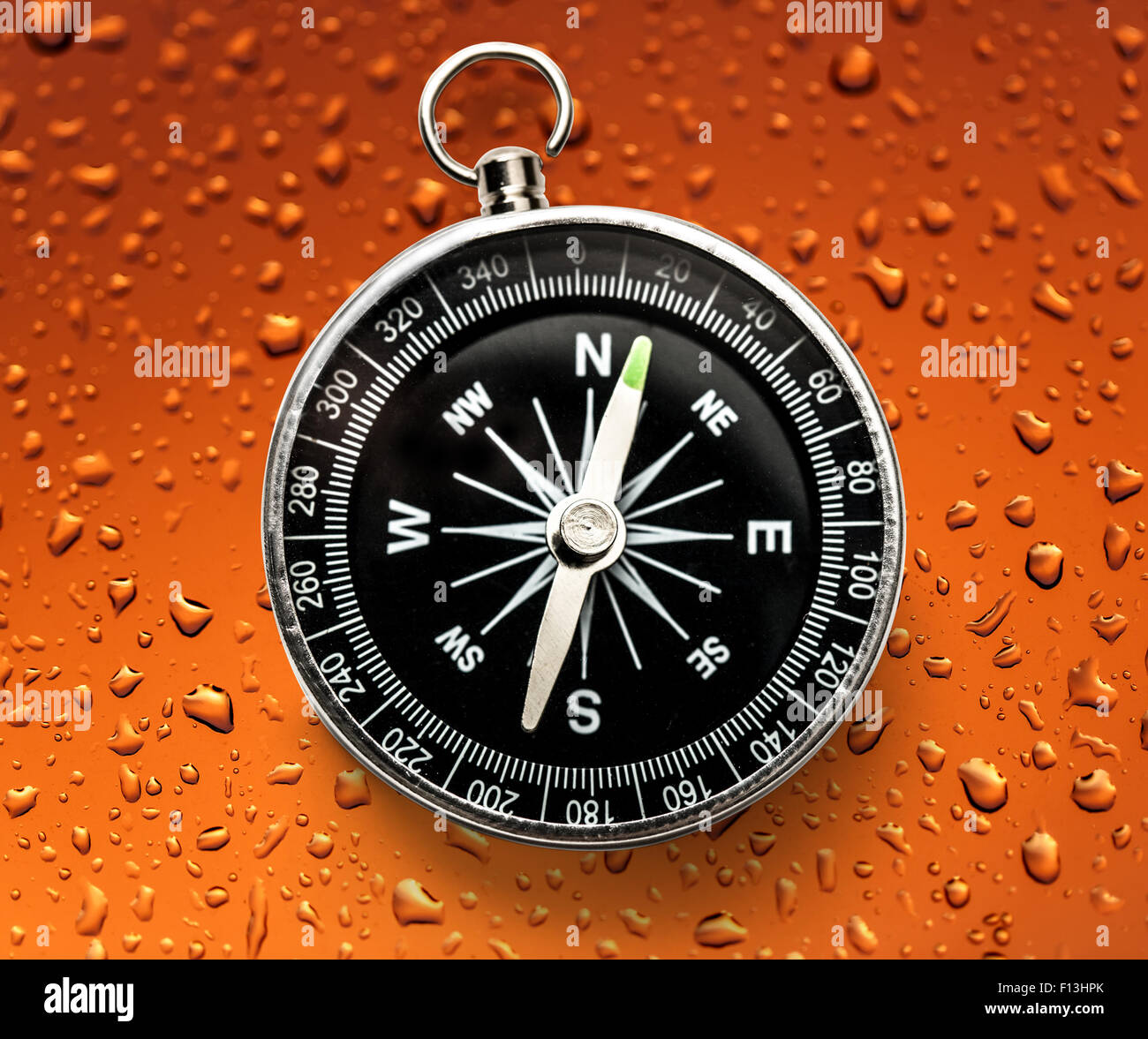 Black compass on the orange raindrop background Stock Photo - Alamy