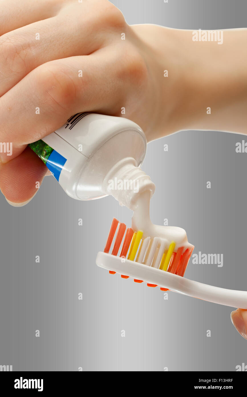 Toothbrush and toothpaste in female hands in closeup Stock Photo - Alamy