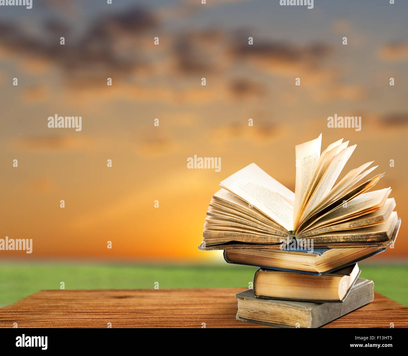 Pile of old books on sky background Stock Photo - Alamy