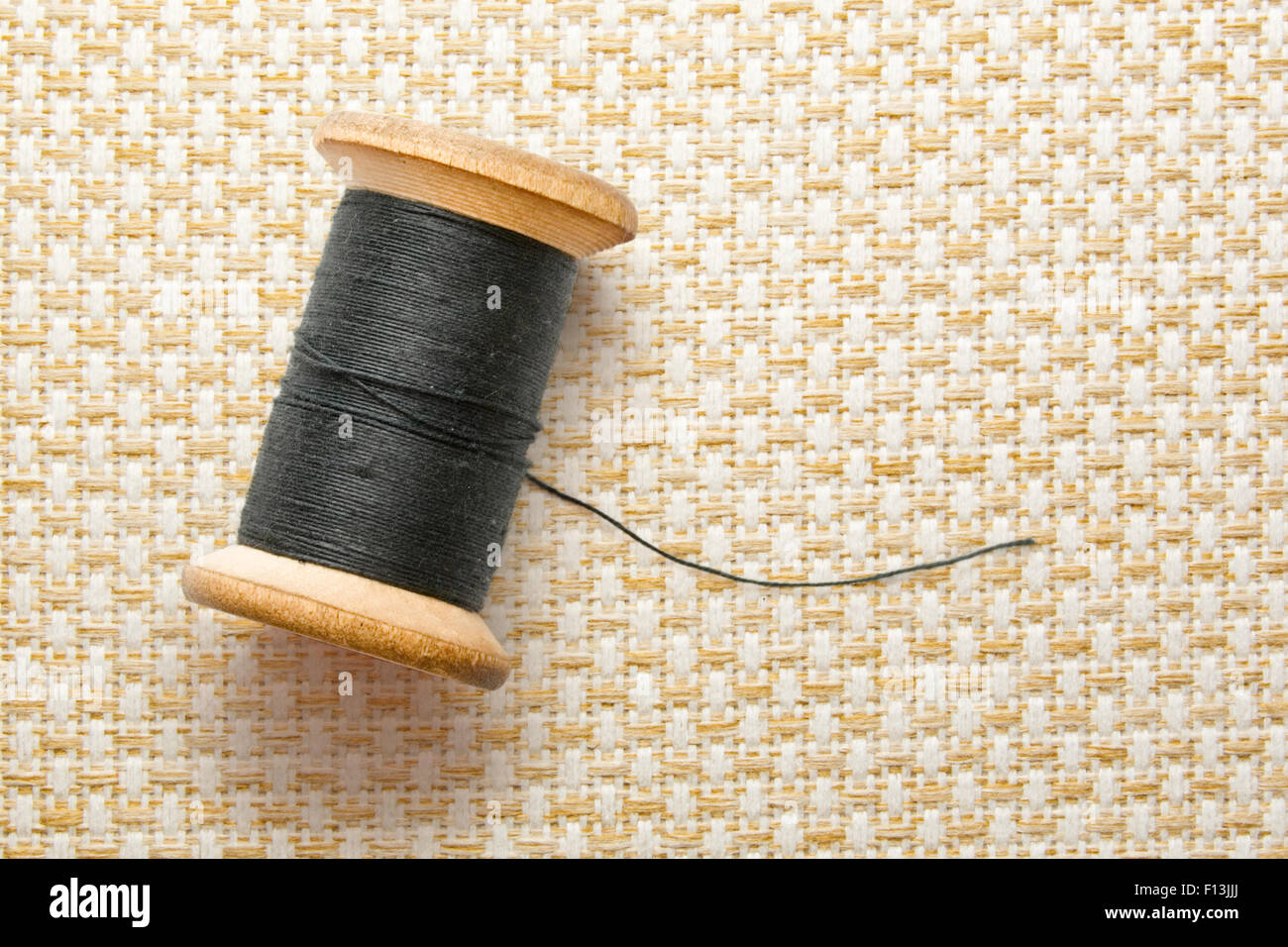 Wooden bobbin of black thread in closeup Stock Photo - Alamy